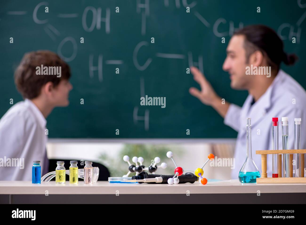 Young chemistry teacher and schoolboy in classroom Stock Photo - Alamy