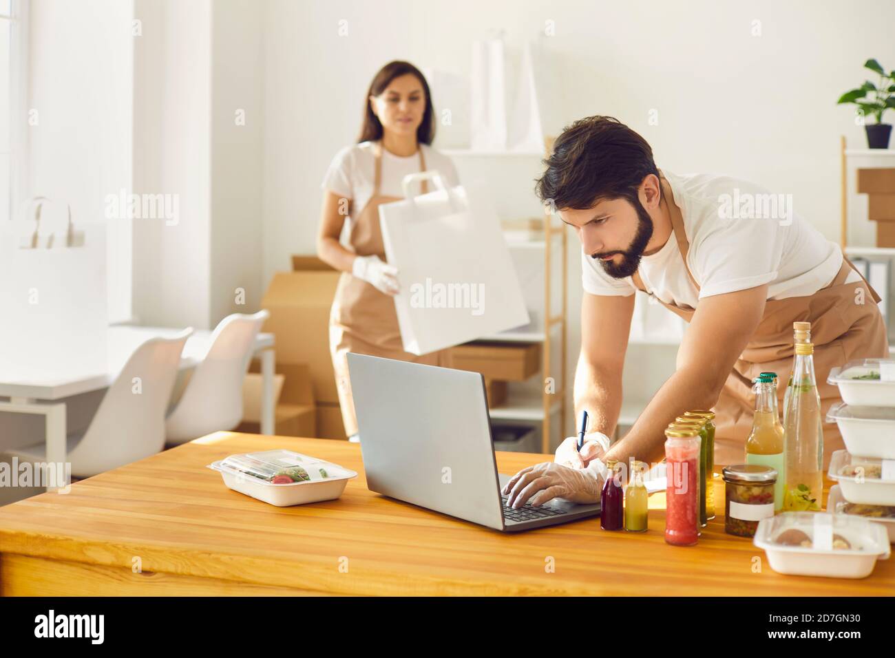 Young workers of food delivery company placing online orders and ...