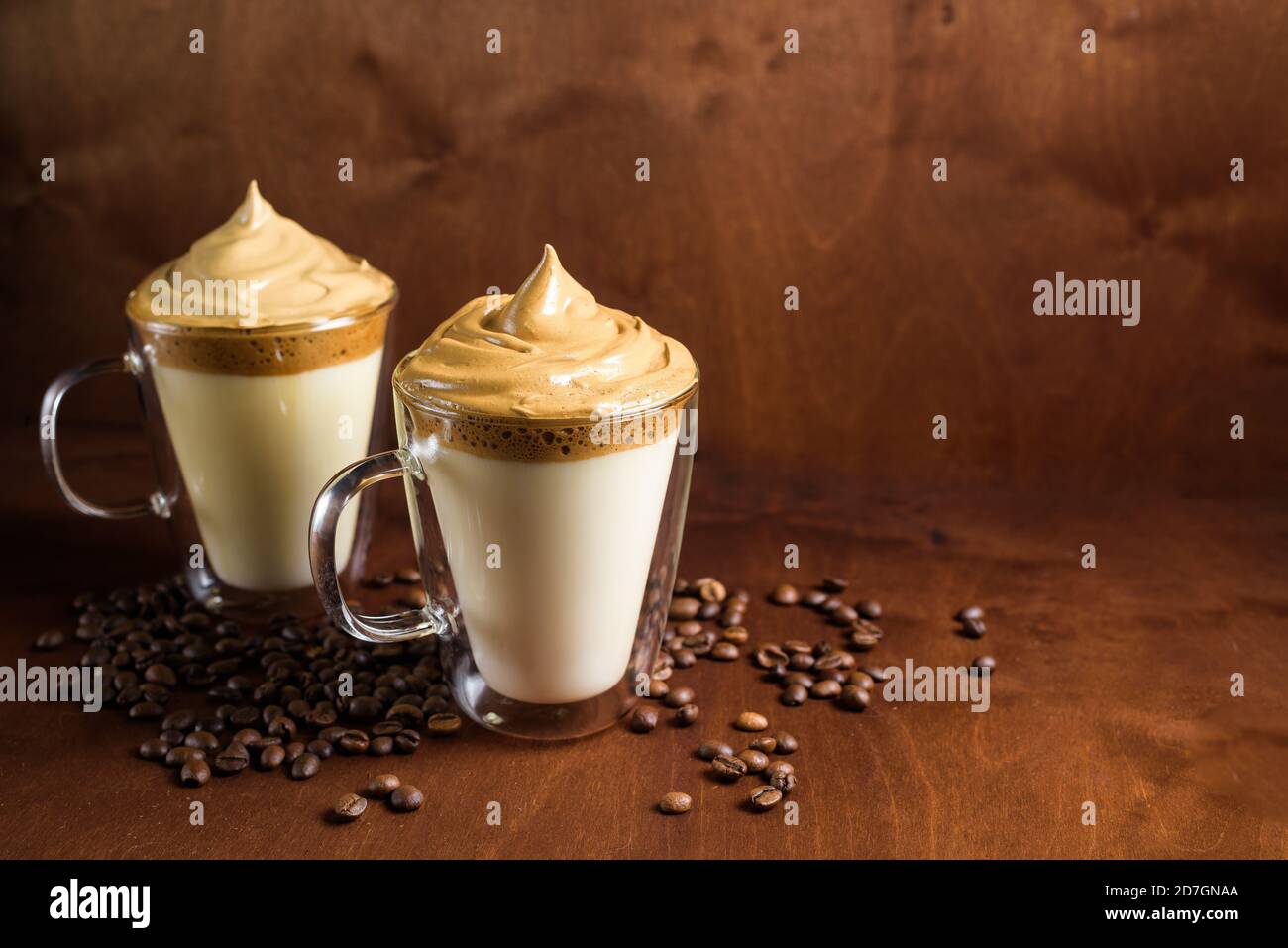 cold dalgon coffee in clear glasses on a dark wooden background. foam ...