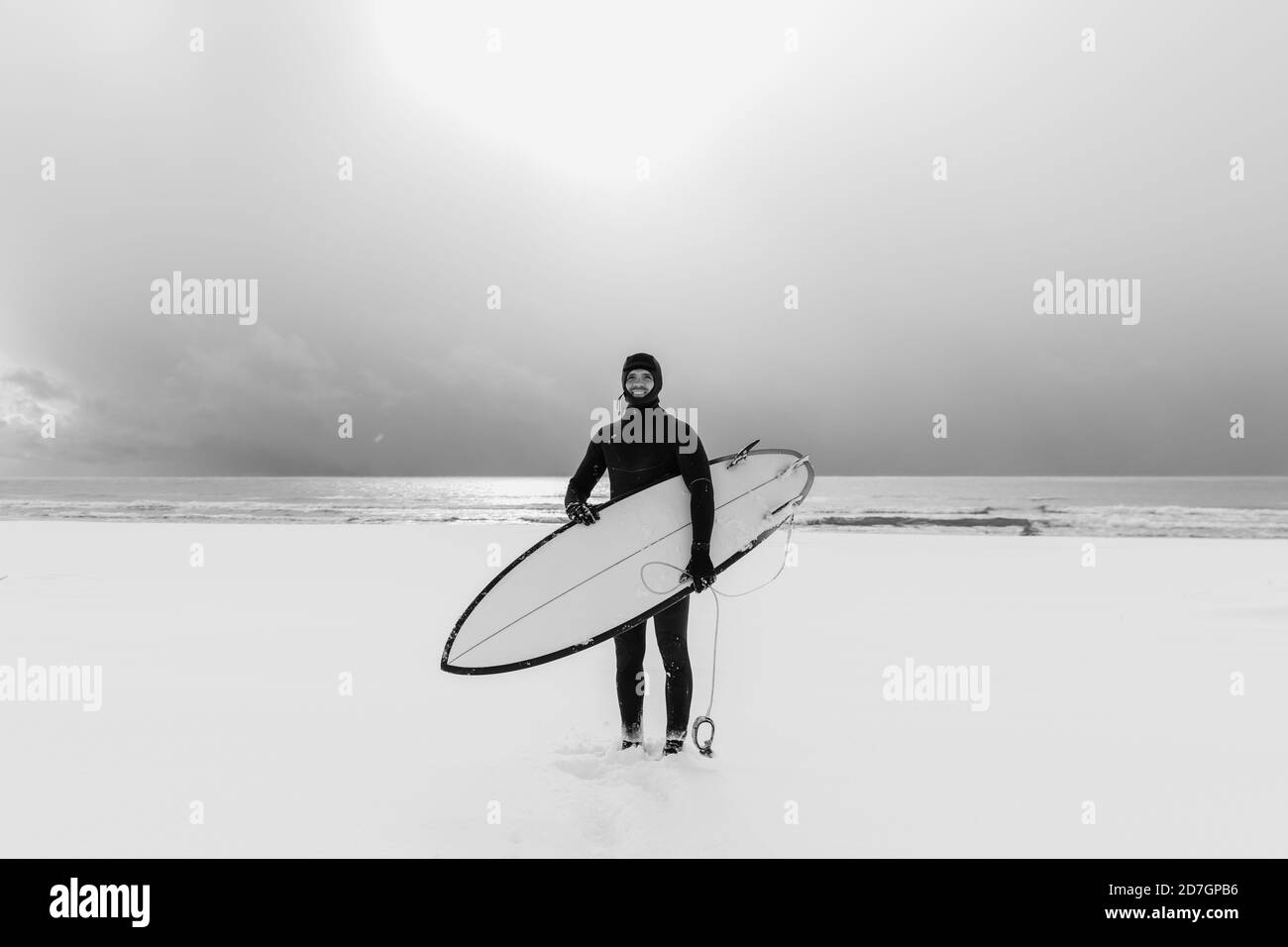 Snowy winter and surfer with surfboard. Winter and surfer in wetsuit ...