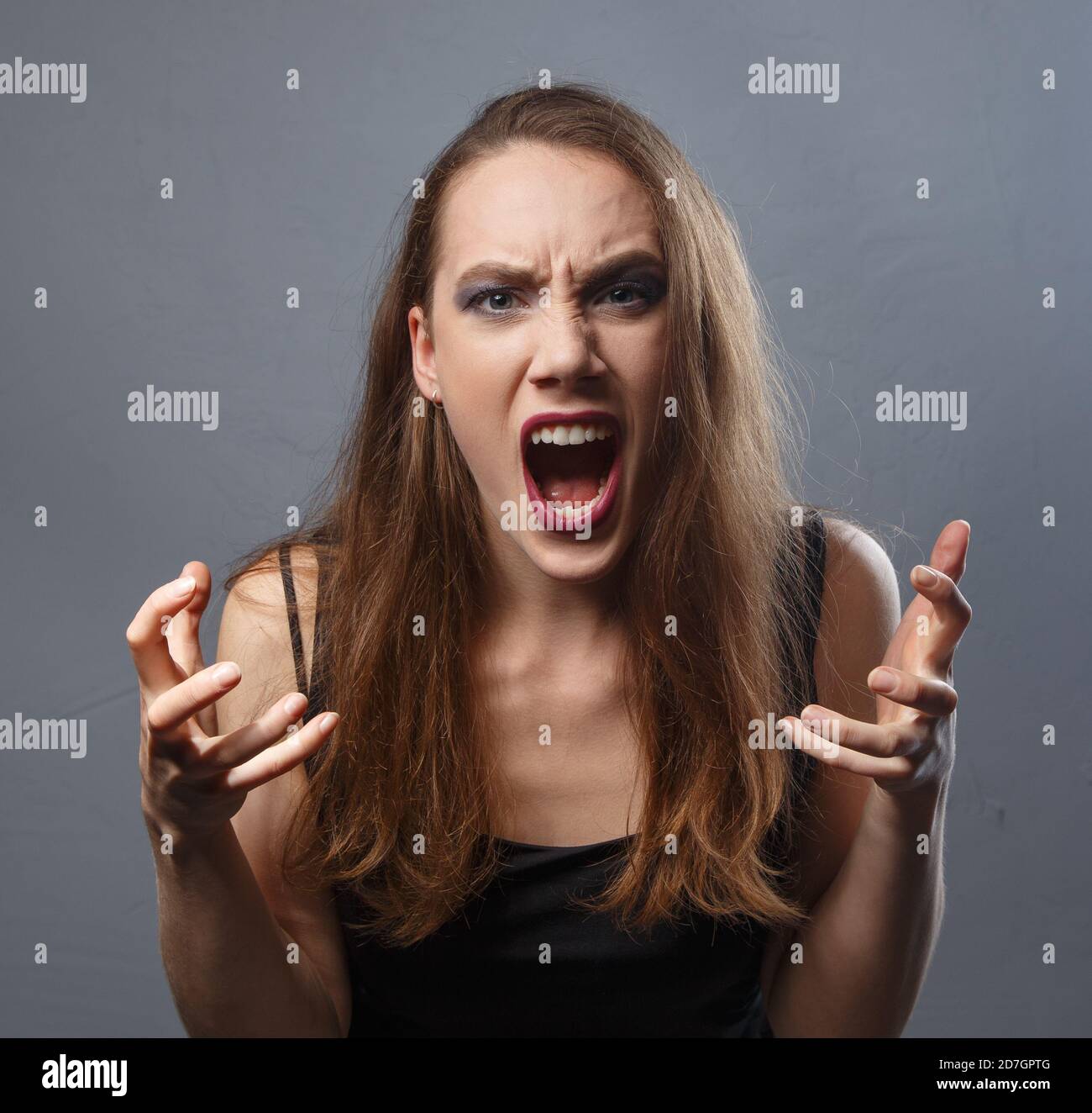 Angry woman with purple lips on grey background Stock Photo - Alamy