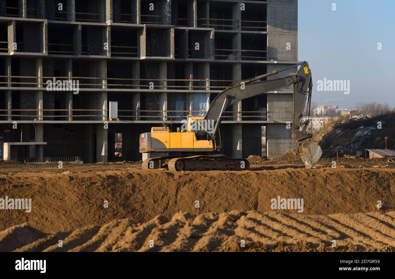 Excavator digs ground at a construction site for installing concrete ...