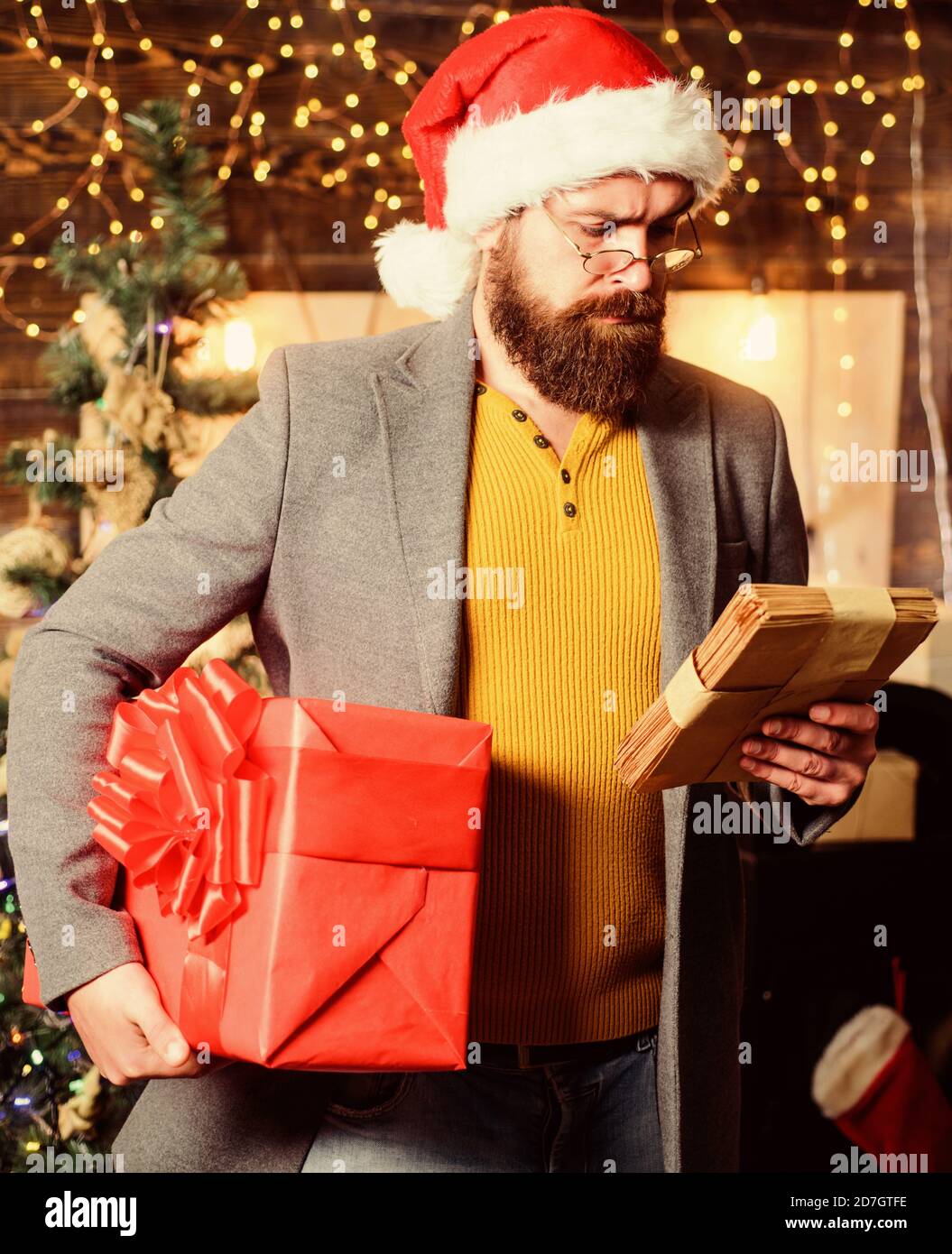 Man bearded hipster wear santa hat hold bunch of letters and gift box ...