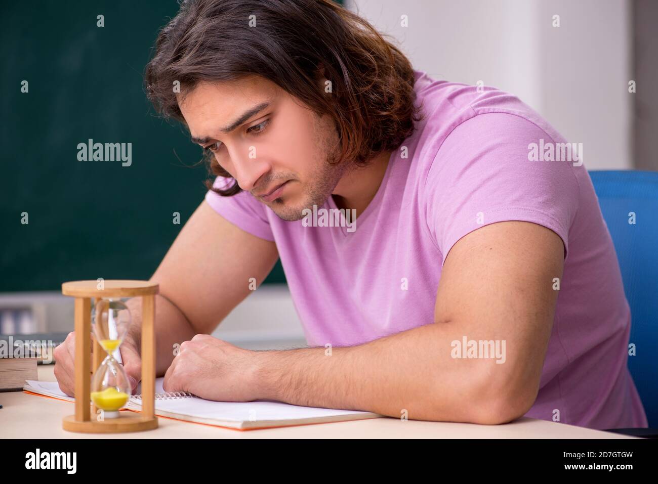 Young student in the classroom at time management concept Stock Photo ...