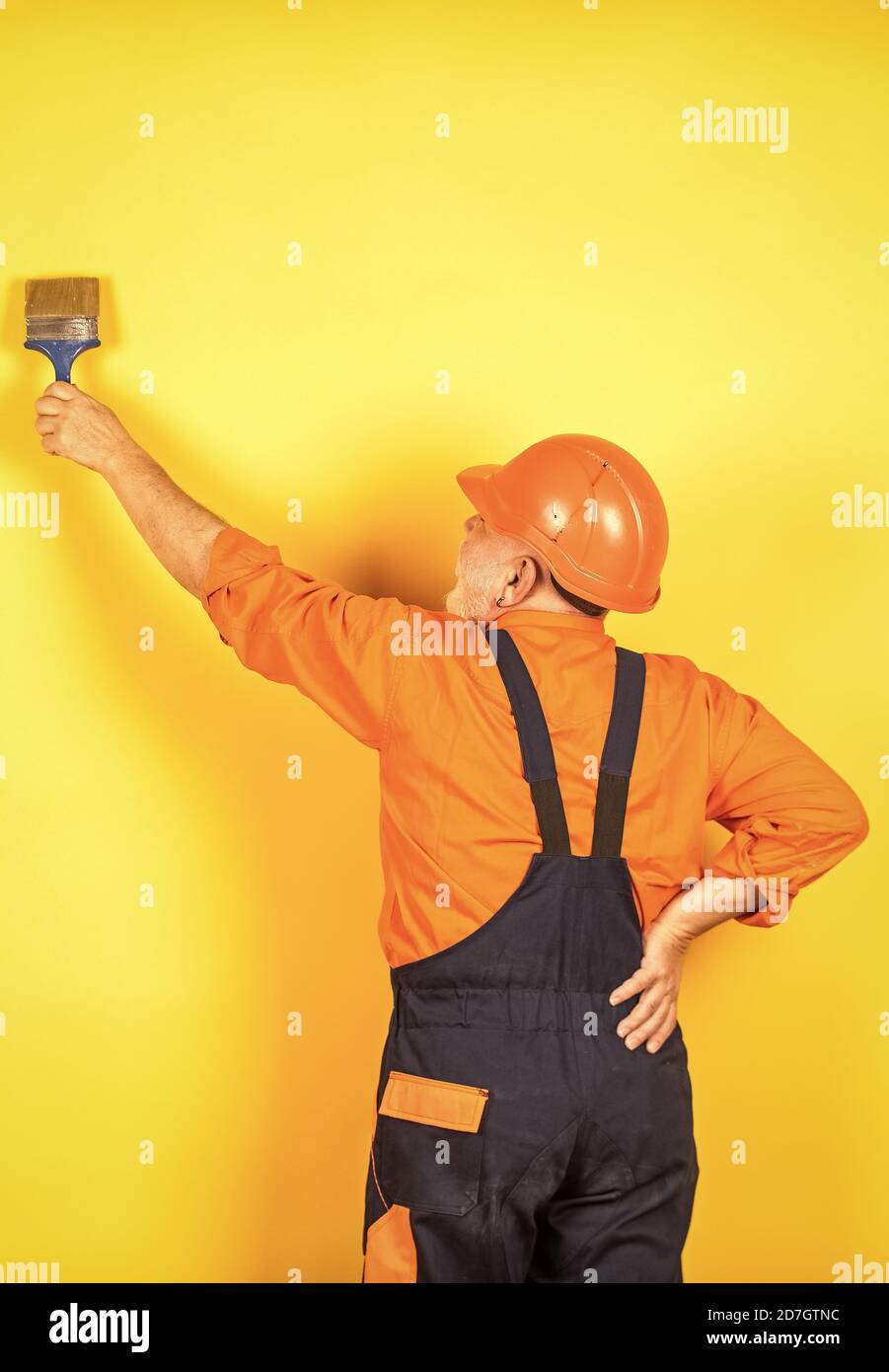 painting yellow wall. painter in working uniform working indoor. man ...
