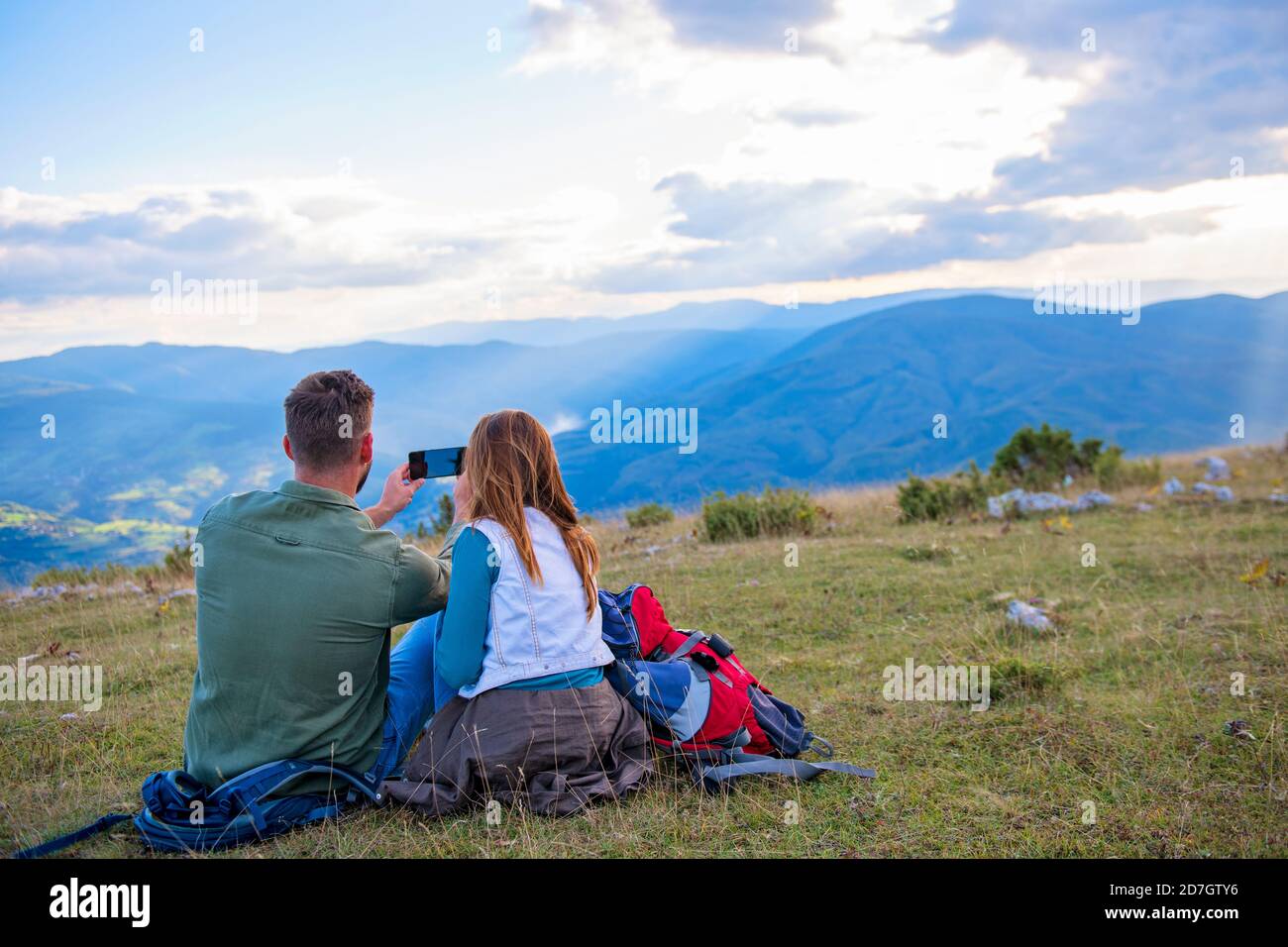 Couple Sitting On A Rock Resting During Hike Stock Photo - Alamy