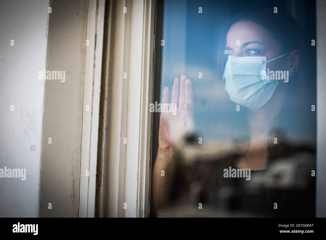 Color image of a woman wearing a surgical mask by a window Stock Photo ...