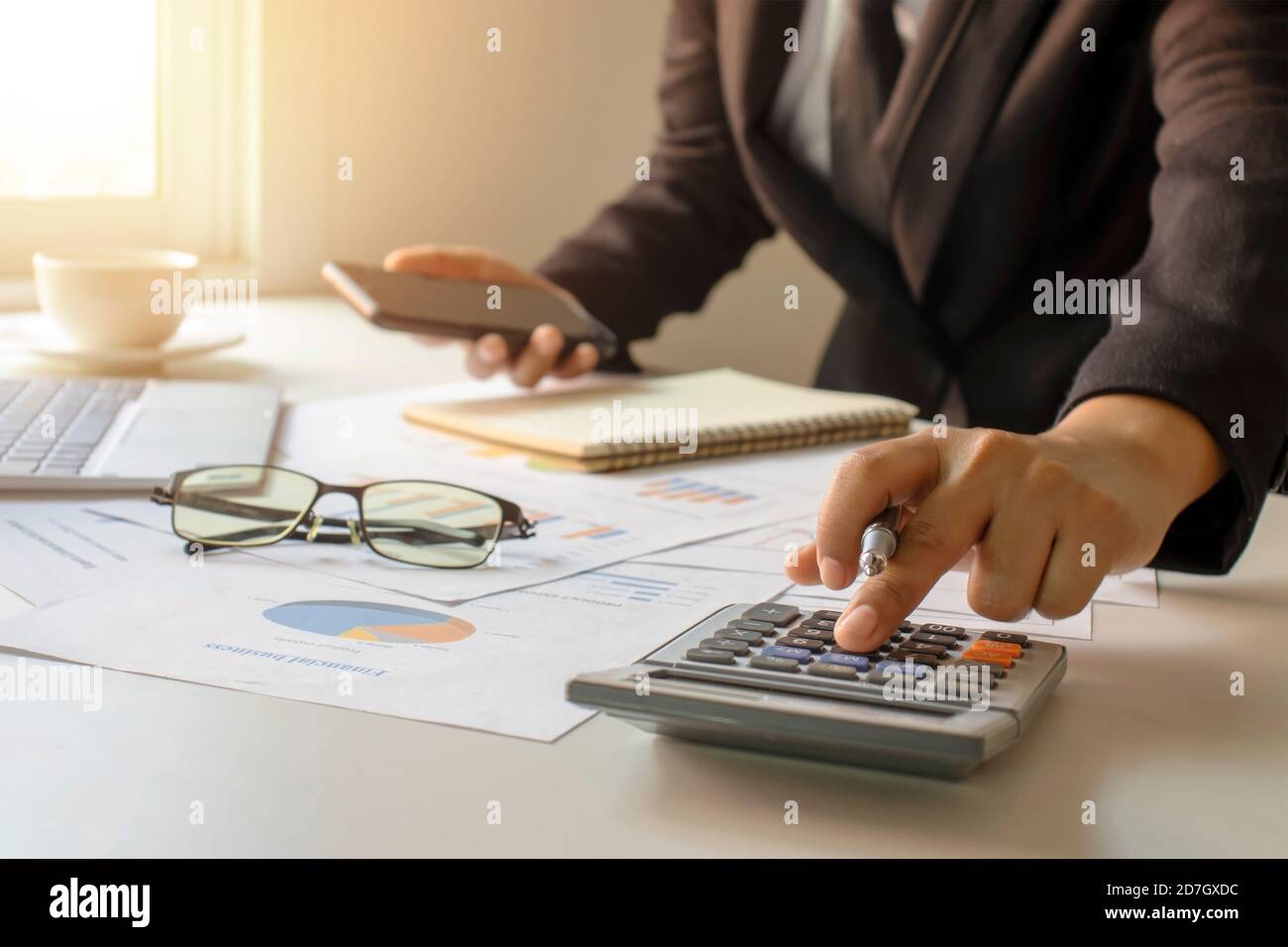 Business people press calculator to calculate office expenses ...