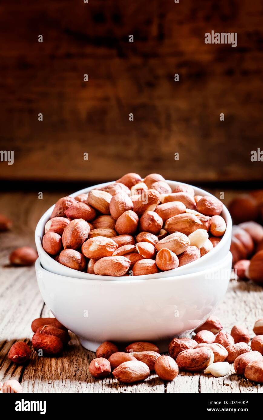 Raw peeled peanuts in a white porcelain bowl, old wooden background ...