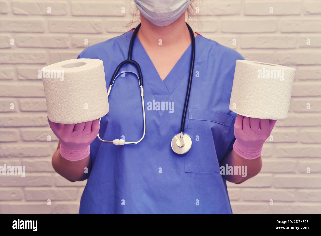 A nurse holds two rolls of white toilet paper. Doctor with a ...