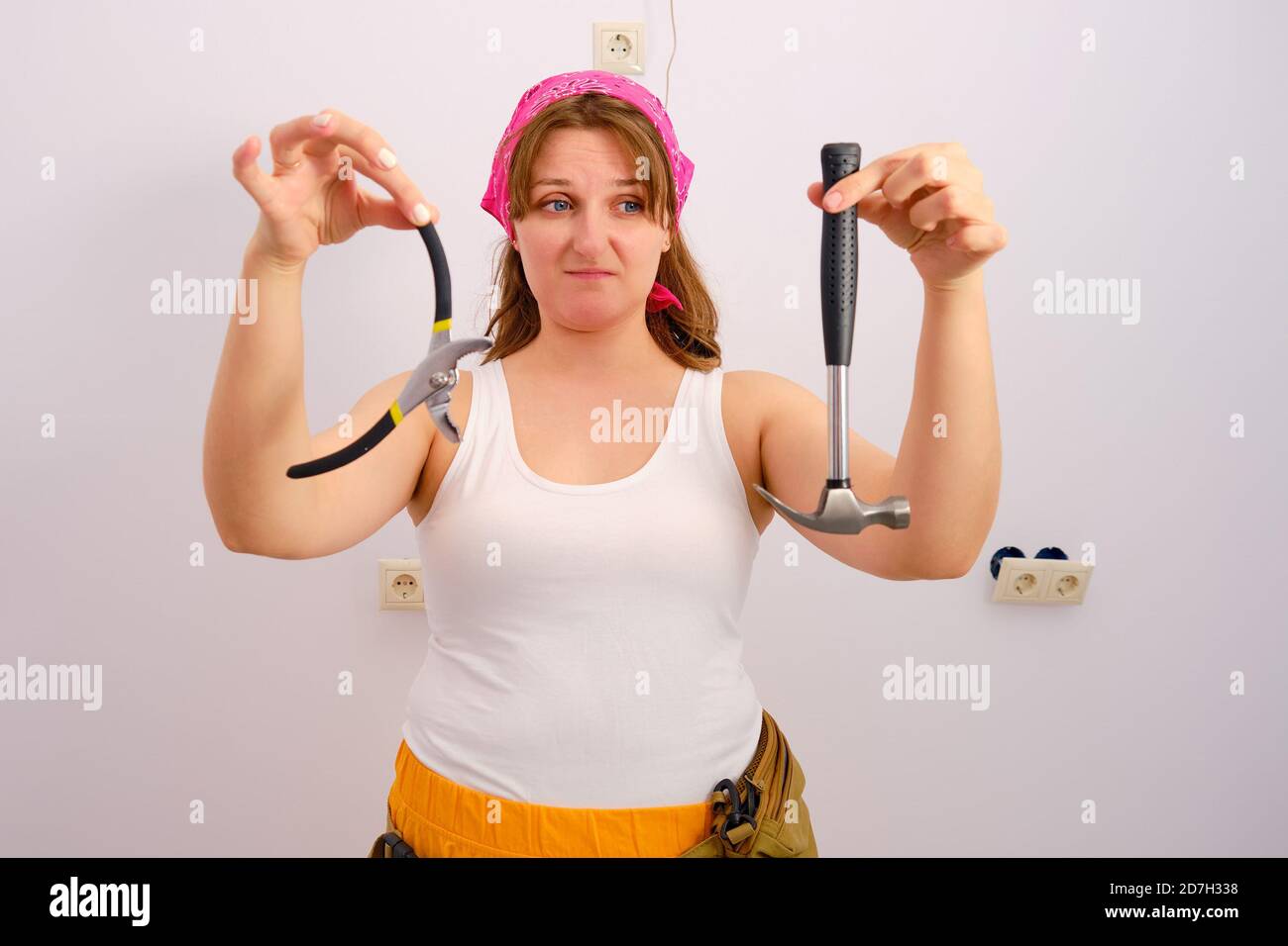 Woman builder holds construction tools with disgust and disdain Stock ...