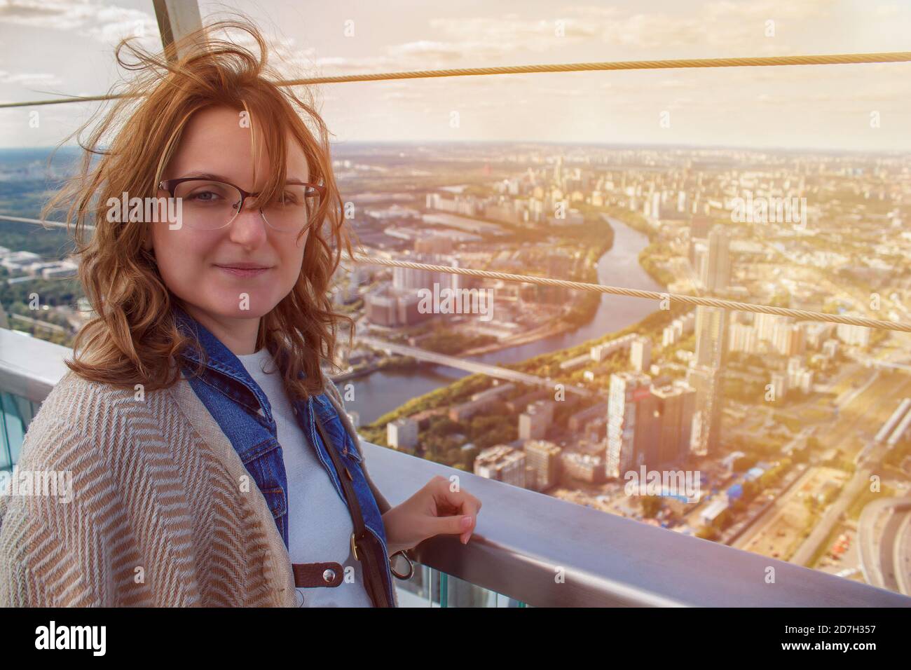 Woman on top of a tall building, below the cityscape. woman sitting on ...
