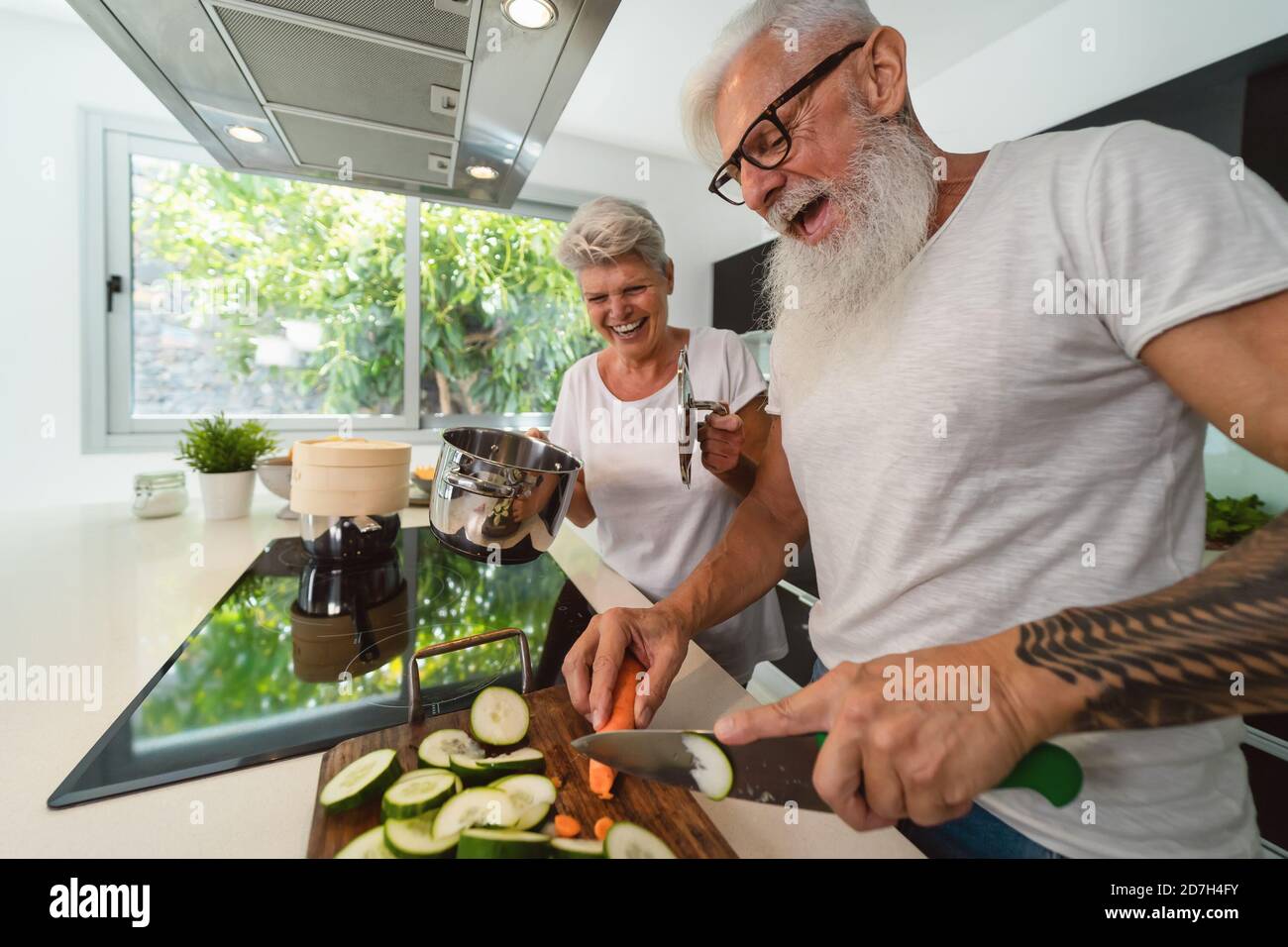 Happy senior couple having fun cooking together at home - Elderly ...