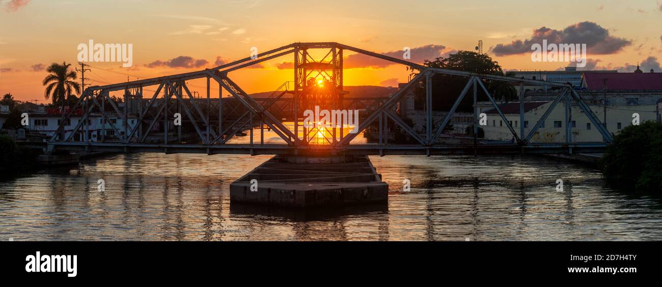 Panoramic view of a metal bridge structure over a calm river with a ...