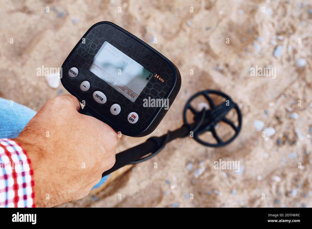 Male hand holding metal detector device above the ground Stock Photo ...