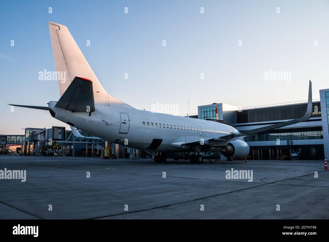 Passenger jet plane parked to a boarding ramp Stock Photo - Alamy