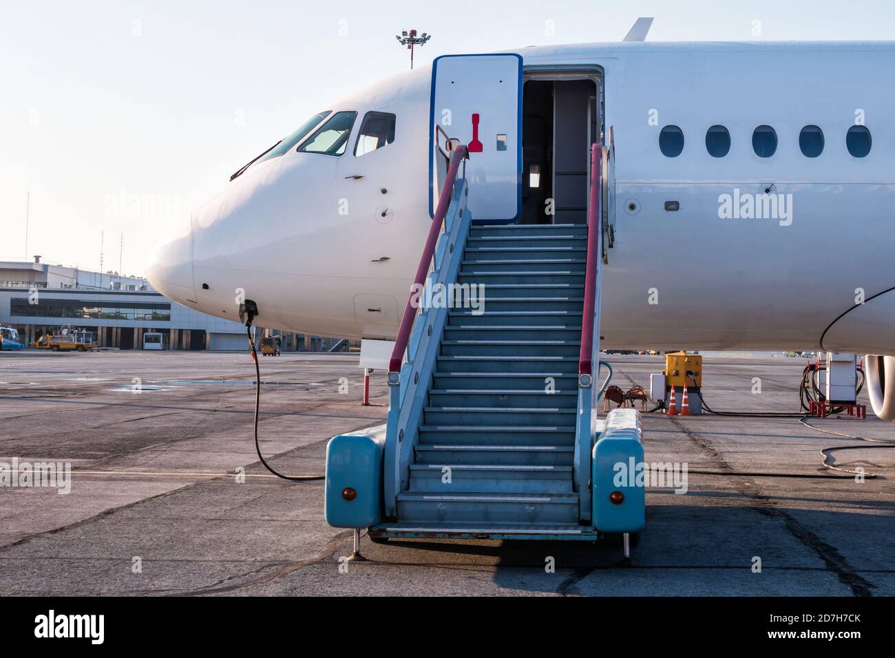 Passenger aircraft with boarding stairs at the airport apron and ...