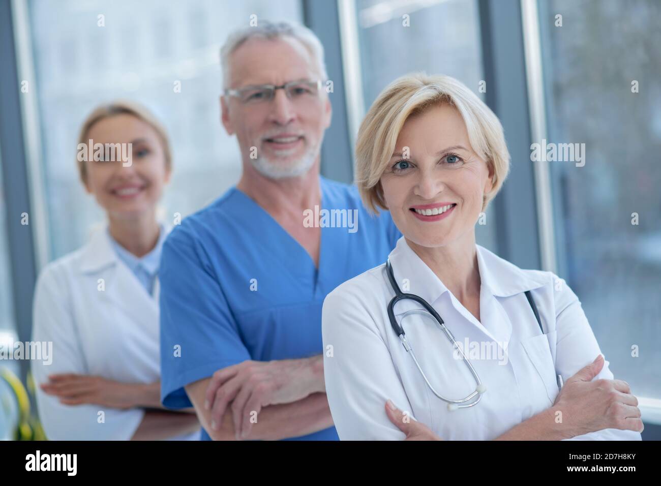 Group of smiling medical workers posing with arms folded Stock Photo ...