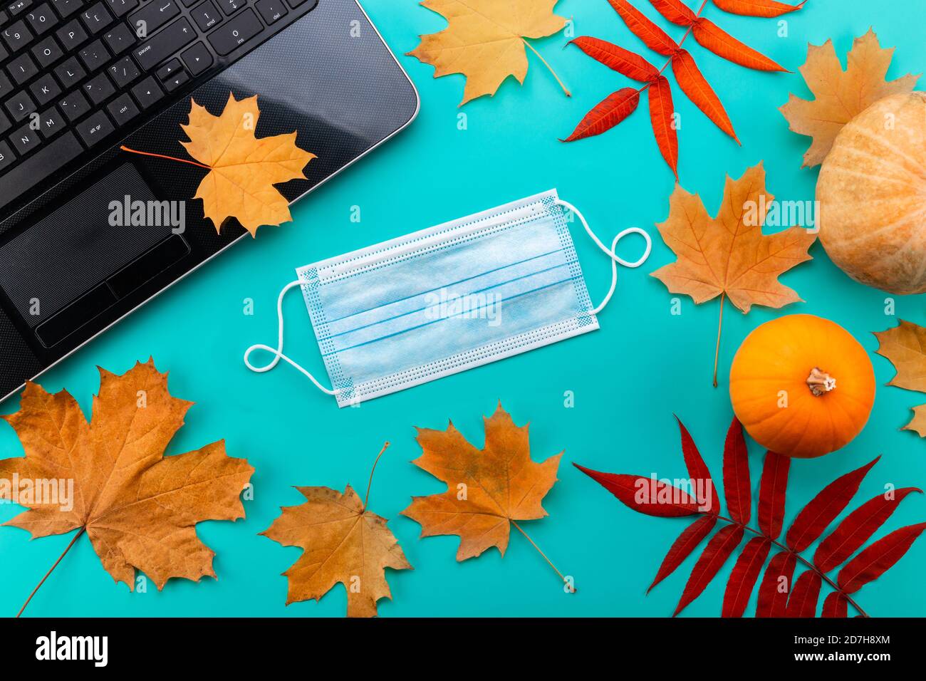 Laptop computer with masks in autumn. Yellow autumn leaves. Top view ...