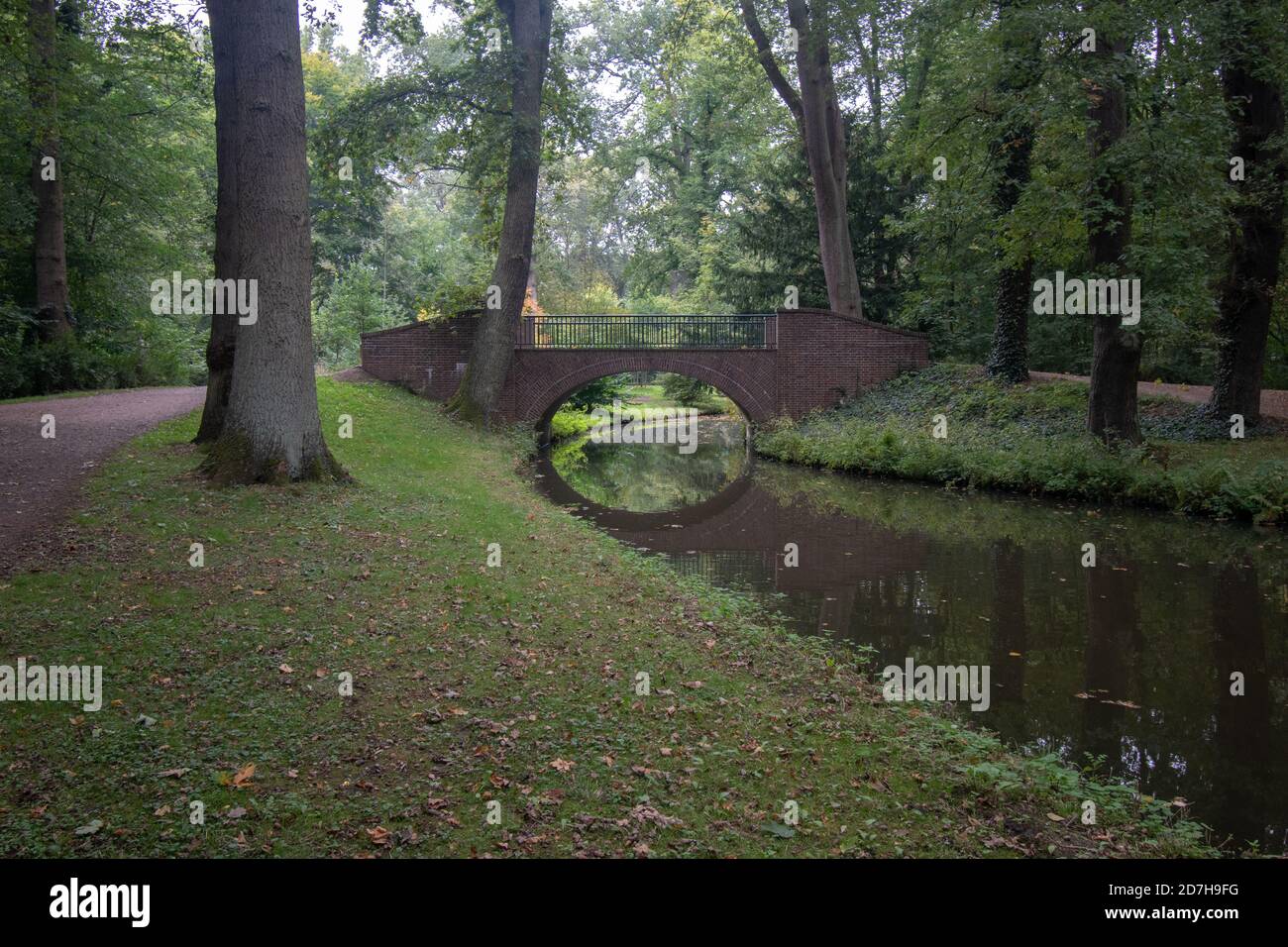 Bridge over a small lake surrounded by greenery in a Bremen park ...