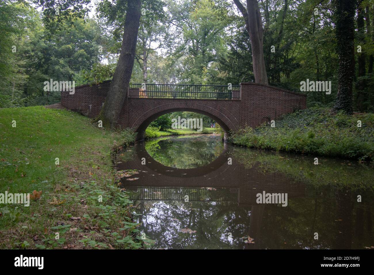 Bridge over a small lake surrounded by greenery in a Bremen park ...