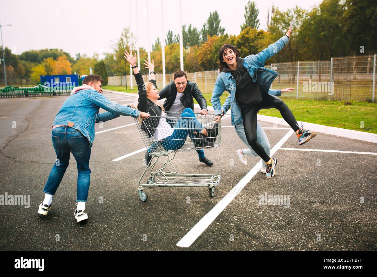 Having fun. Group of four young diverse friends in jeanse outfit look ...
