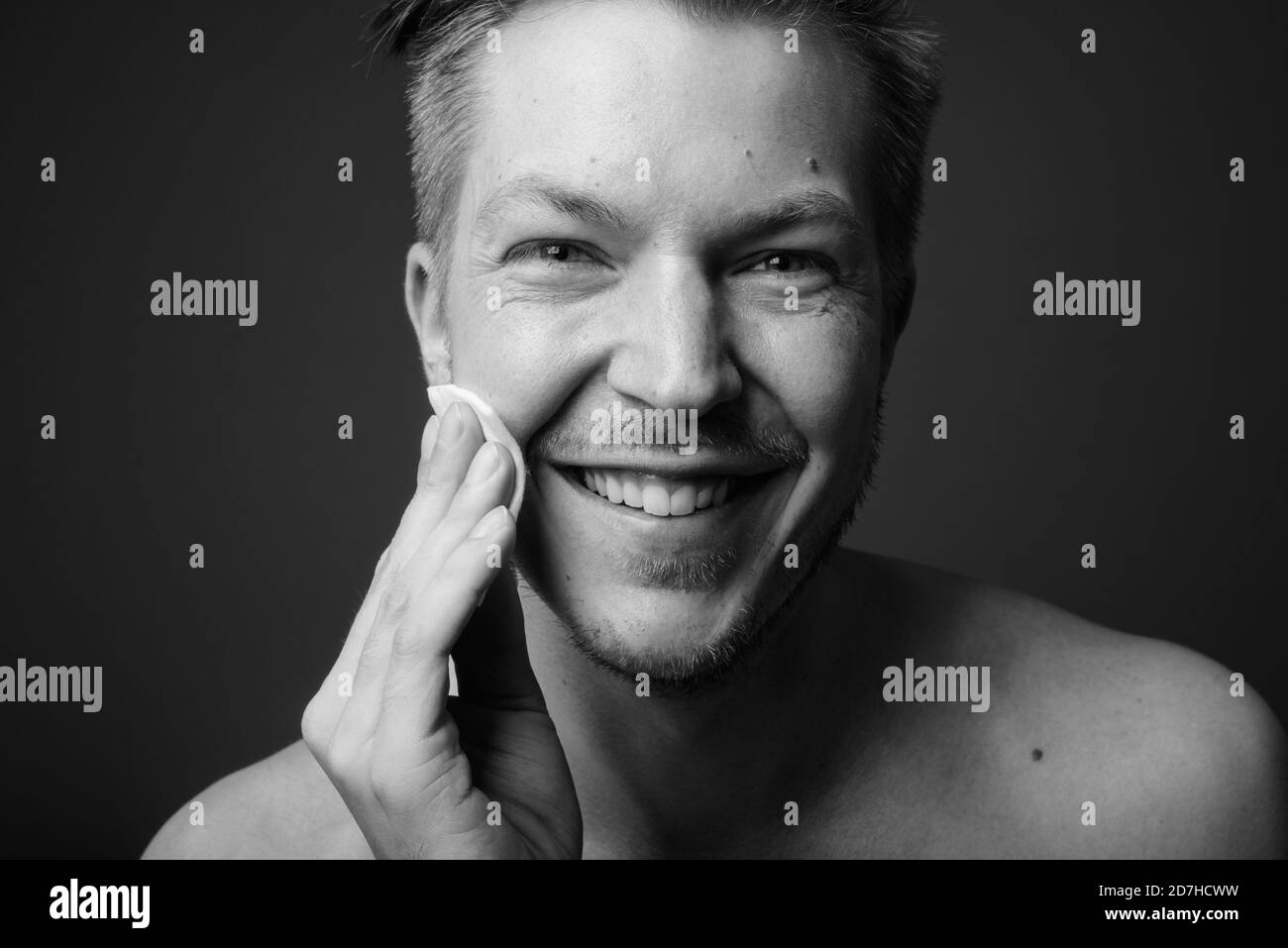 Young handsome man shirtless while grooming against gray background Stock Photo - Alamy