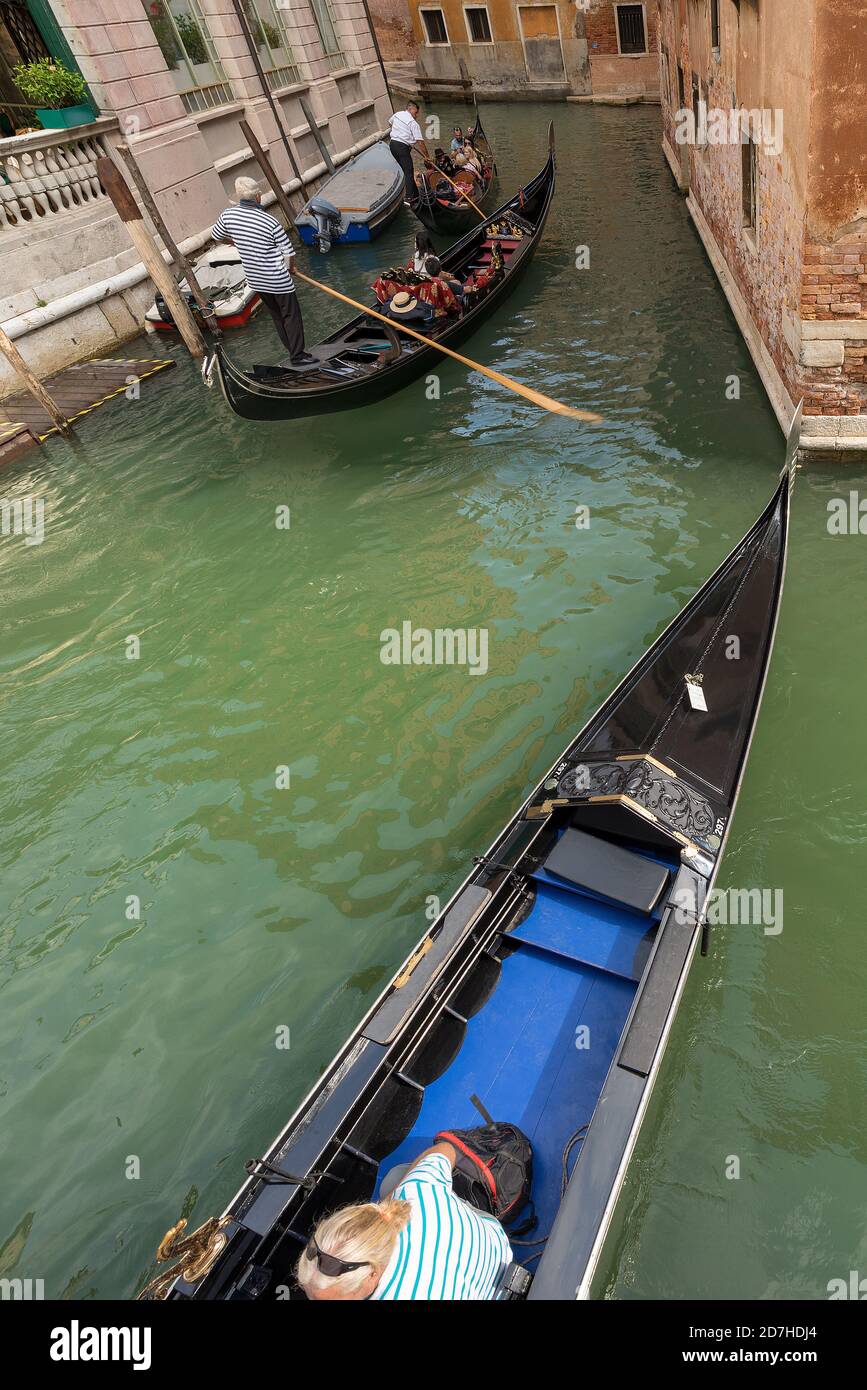 Gondoliers and tourists on the gondolas, typical Venetian rowing boat ...