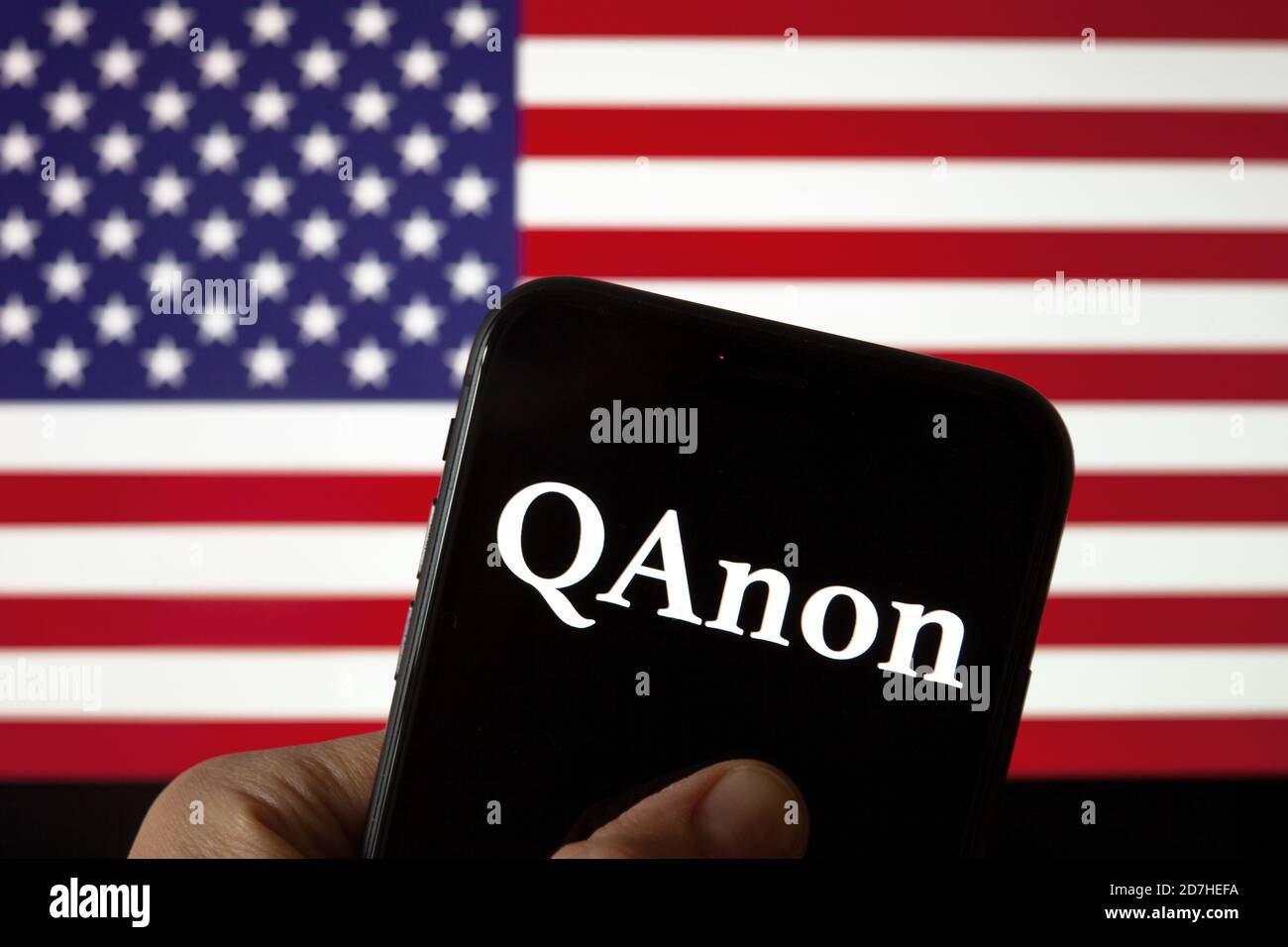 QAnon organisation logo seen on the smartphone which is placed on USA ...
