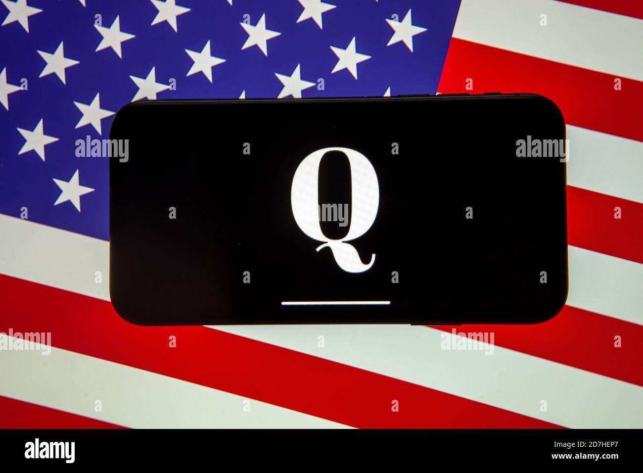 QAnon organisation logo seen on the smartphone which is placed on USA ...