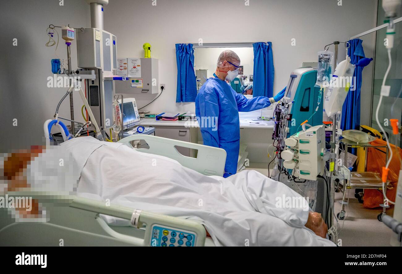 A health worker wearing full personal protective equipment (PPE) tends ...