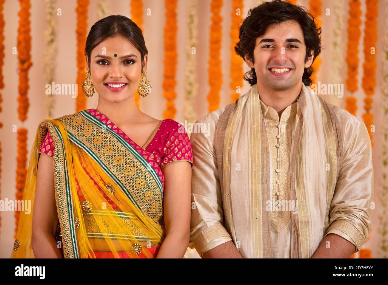 young couple happily posing together in traditional wear Stock Photo ...