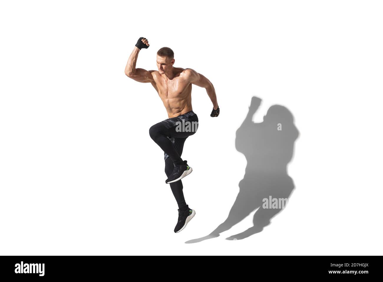 Running, jumping high. Stylish young male athlete on white studio ...