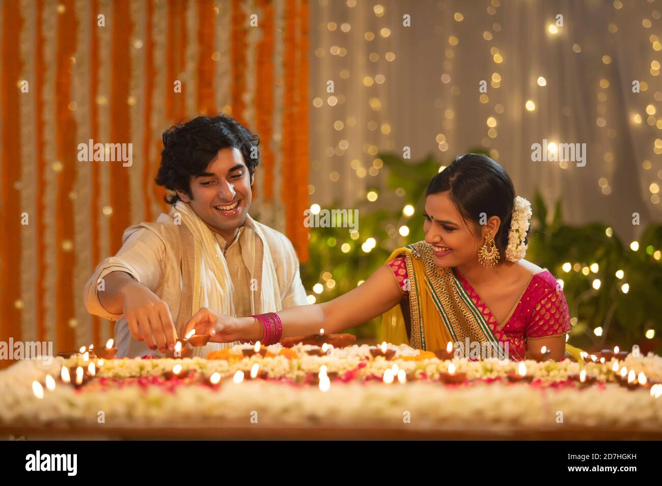 Young couple bonding over lighting diyas Stock Photo - Alamy