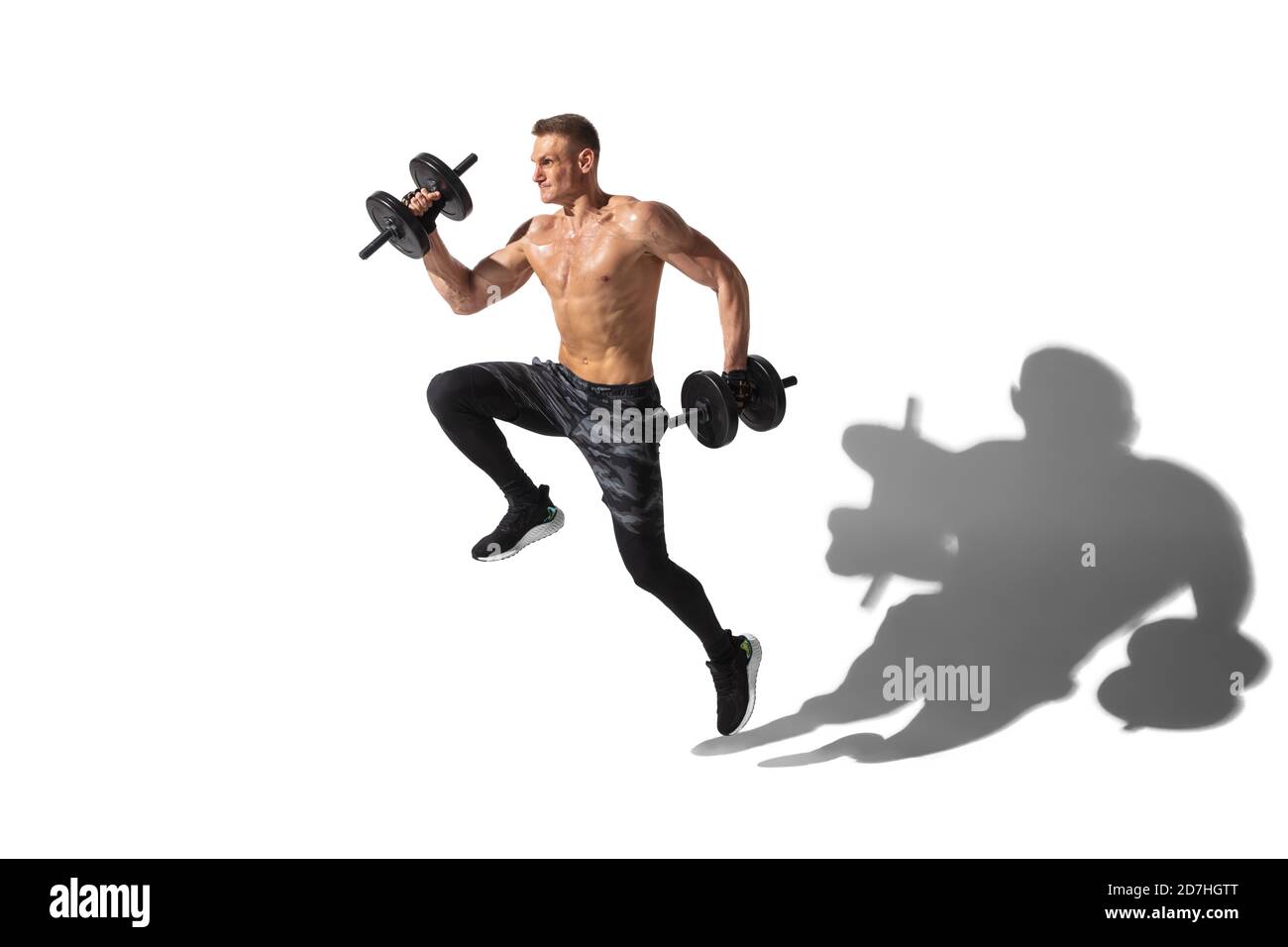 Weights and dumbbells. Stylish young male athlete on white studio ...