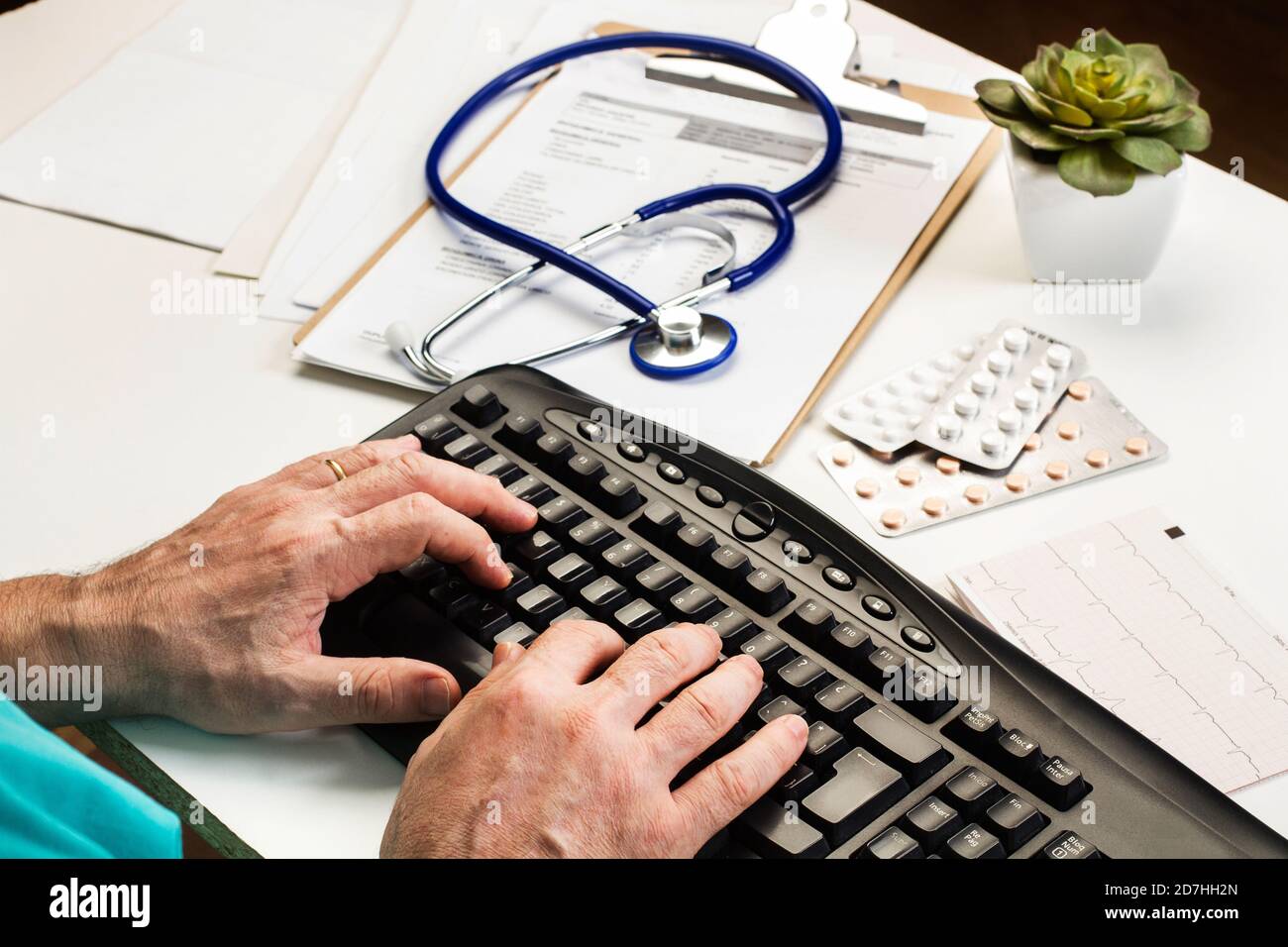 Doctor typing a prescription on a computer on his desk Stock Photo - Alamy