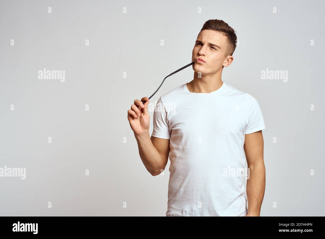 Guy with kitchen tools in hands on a light background cropped view of ...