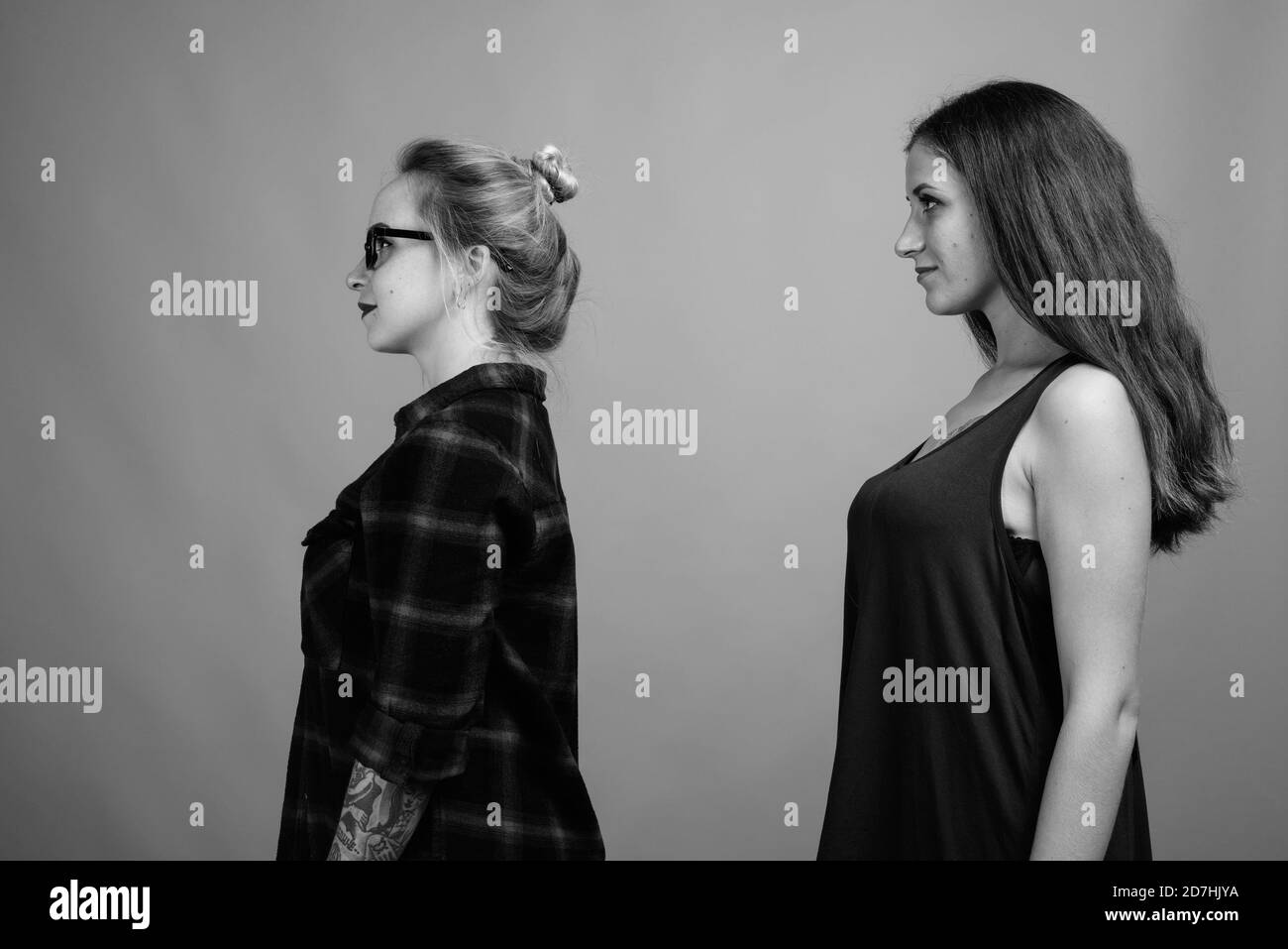 Two young beautiful woman friends against gray background Stock Photo ...