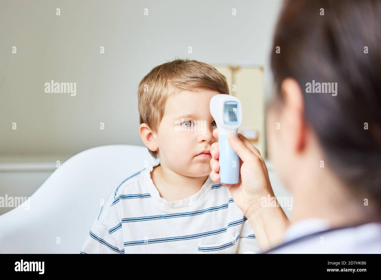 Pediatrician measuring a child's fever with an infrared forehead ...