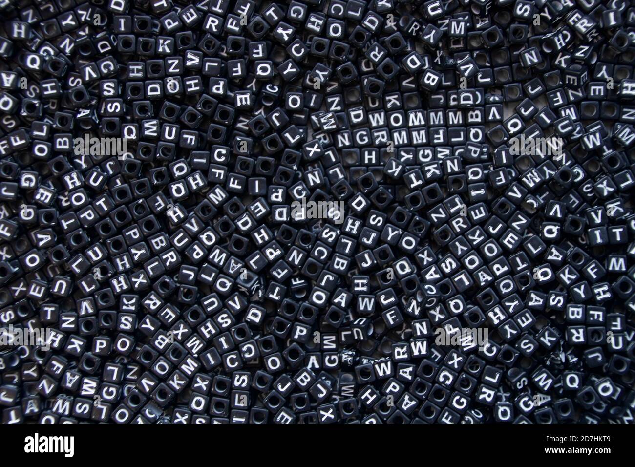 Cluster of black cube-shaped beads with white letters Stock Photo - Alamy