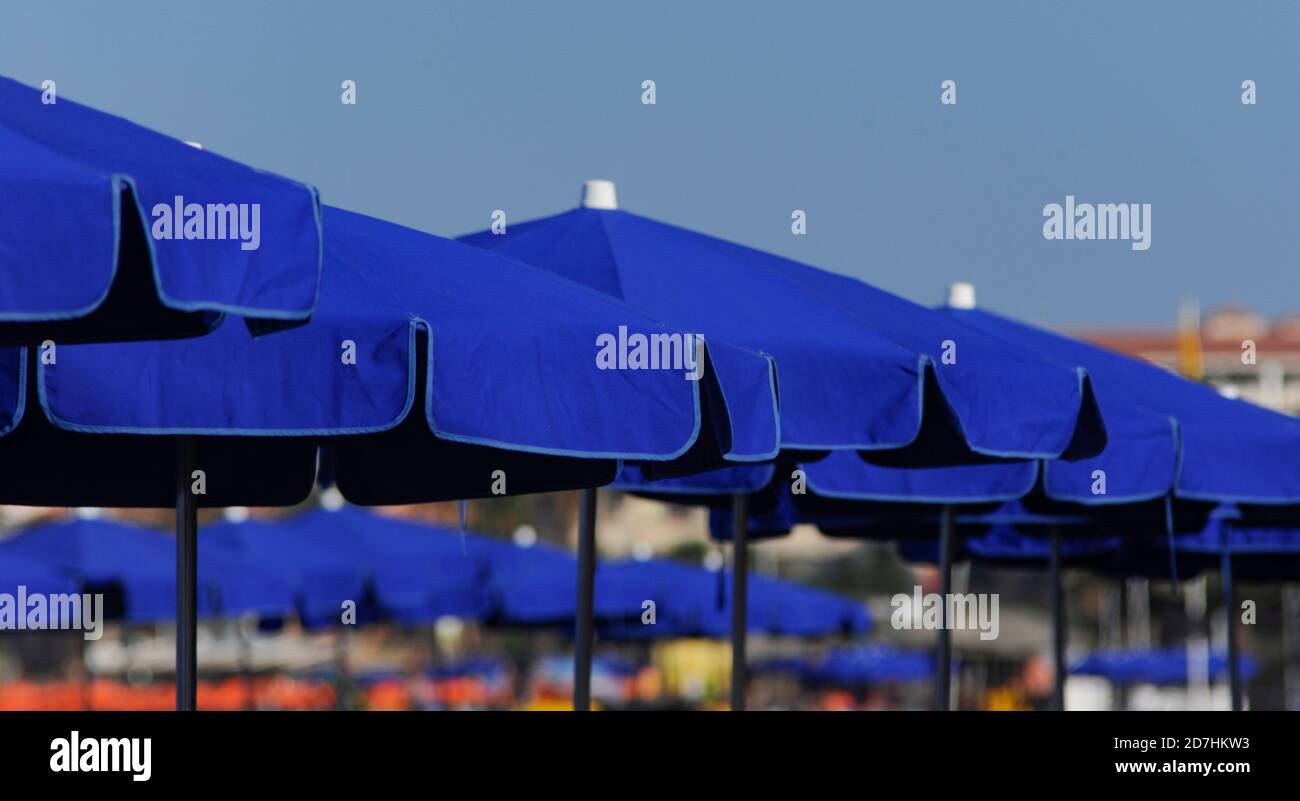 Blue parasols lined up at the beach, durable sun umbrellas providing ...