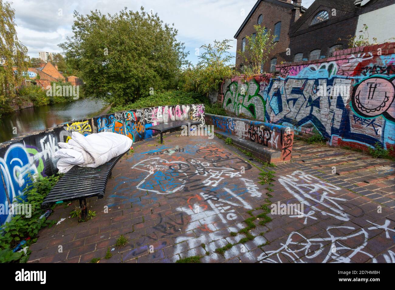 Seating area in Digbeth by a canal, with dumped bedding and grafitti ...