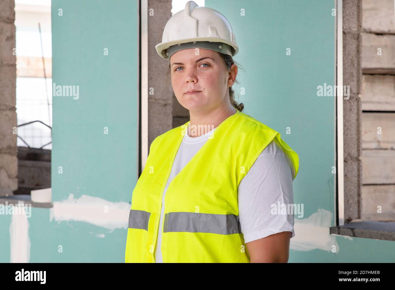 Attractive female architect wearing a white helmet and safety vest ...
