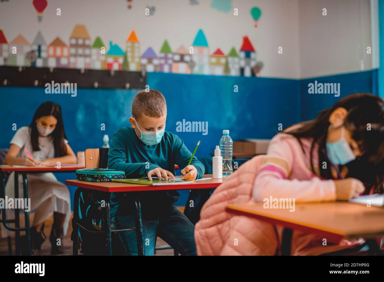 Elementary schoolchildren wearing a protective face masks in the ...