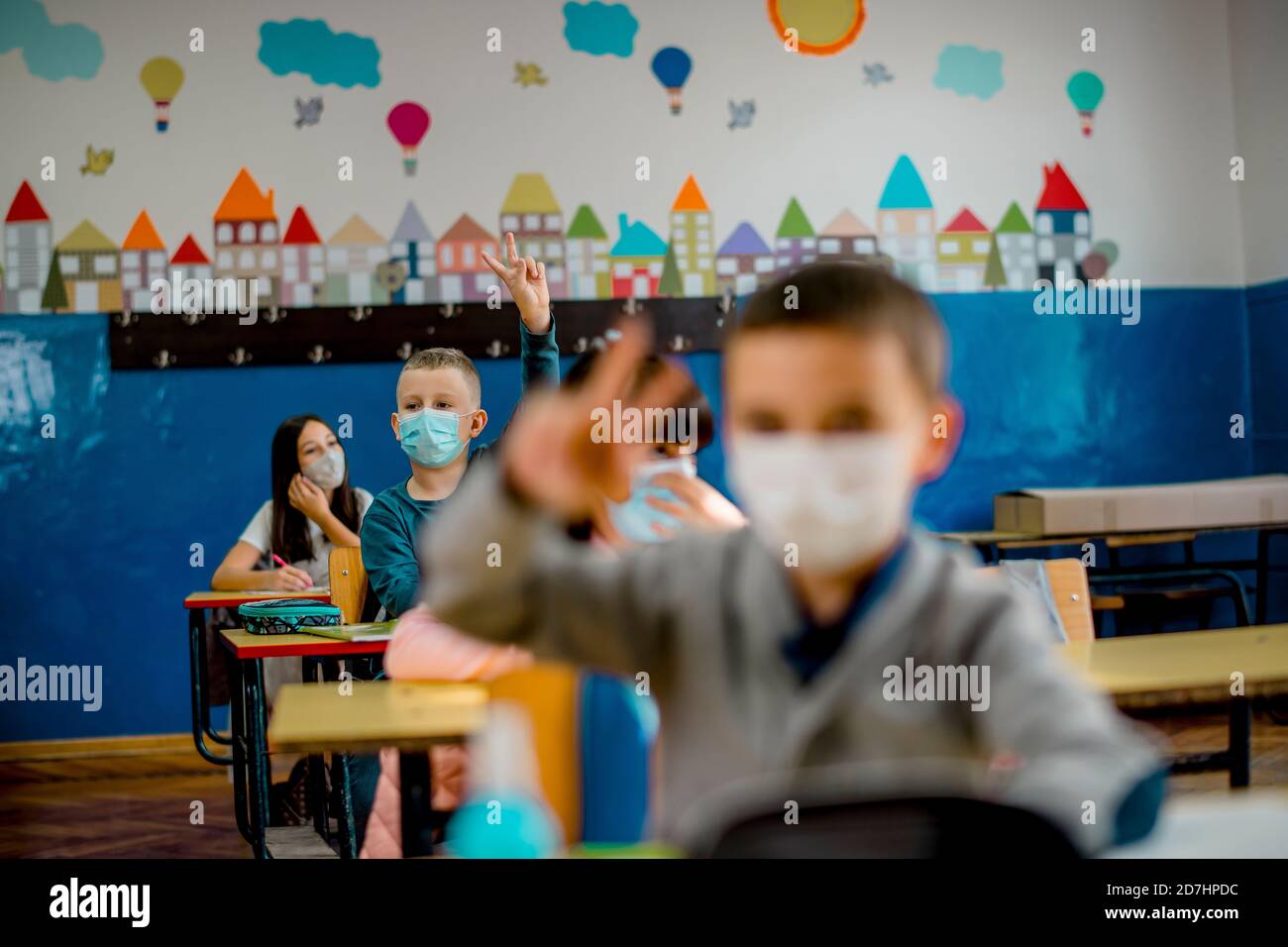 Elementary schoolchildren wearing a protective face masks in the ...