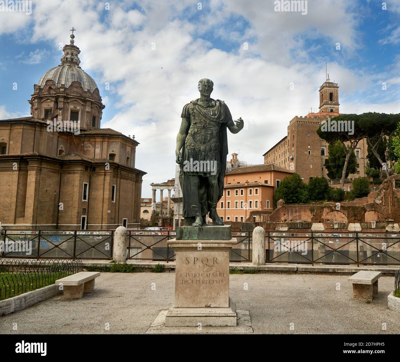 An ancient statue of Cesar in Rome Italy. Church and blue sky with ...