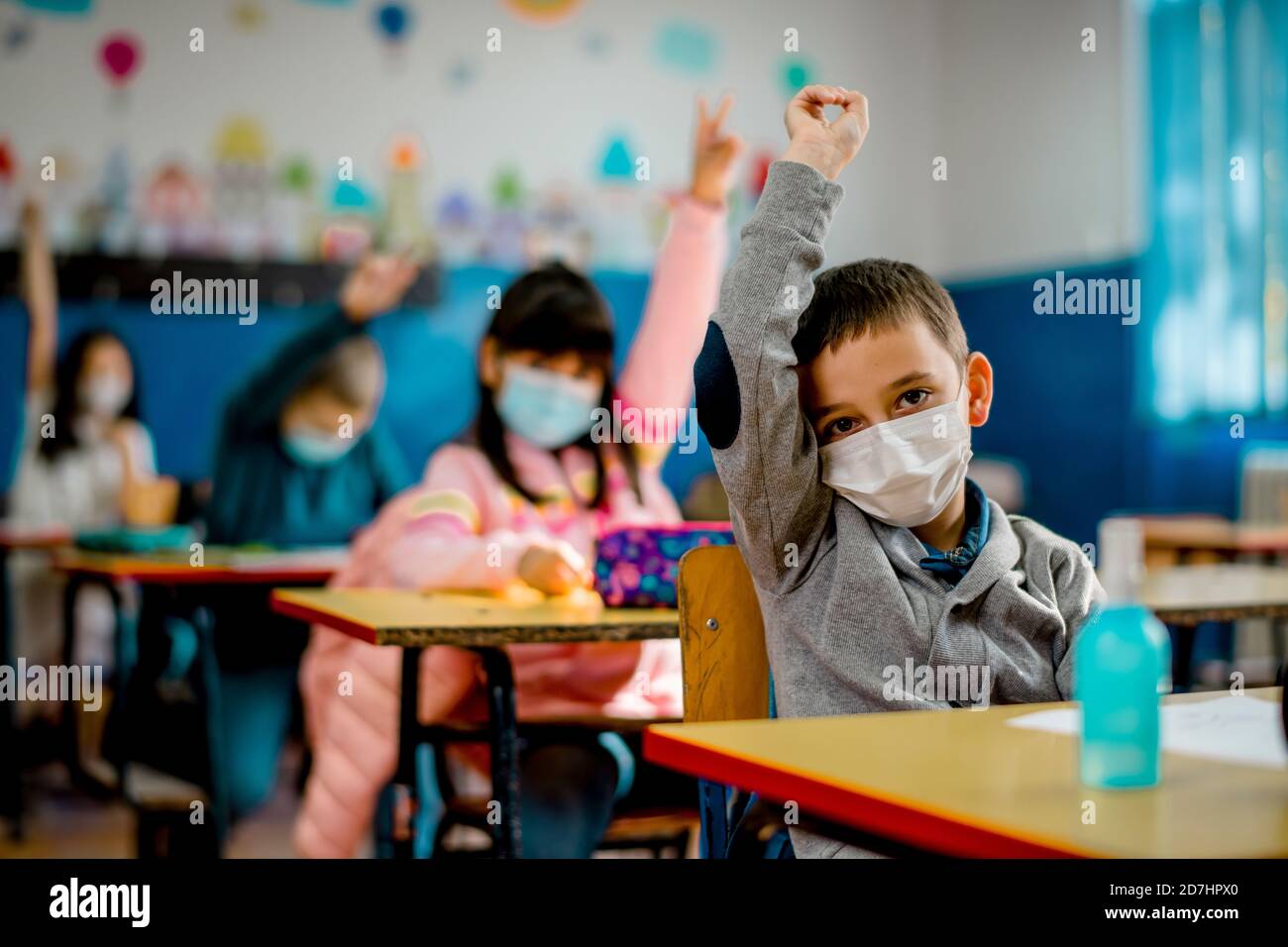 Elementary schoolchildren wearing a protective face masks in the ...