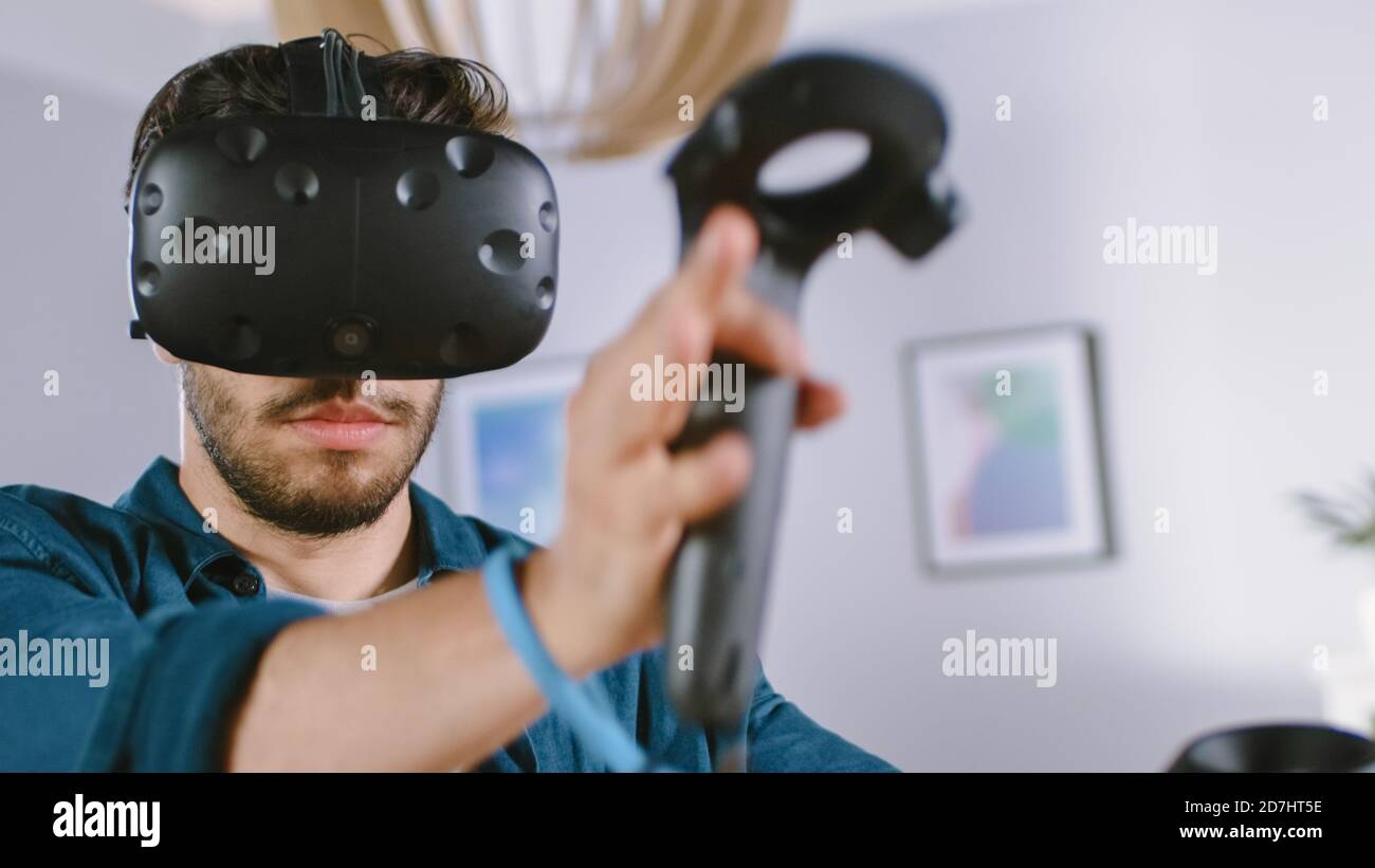 Gamer is standing and using a vr headset and controllers hi-res stock ...