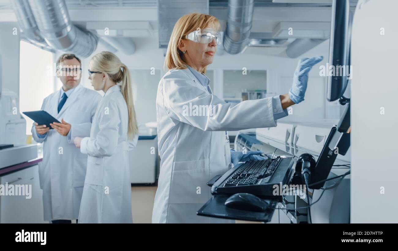 Male and Female Scientists Talking, Using Digital Tablet, Senior ...
