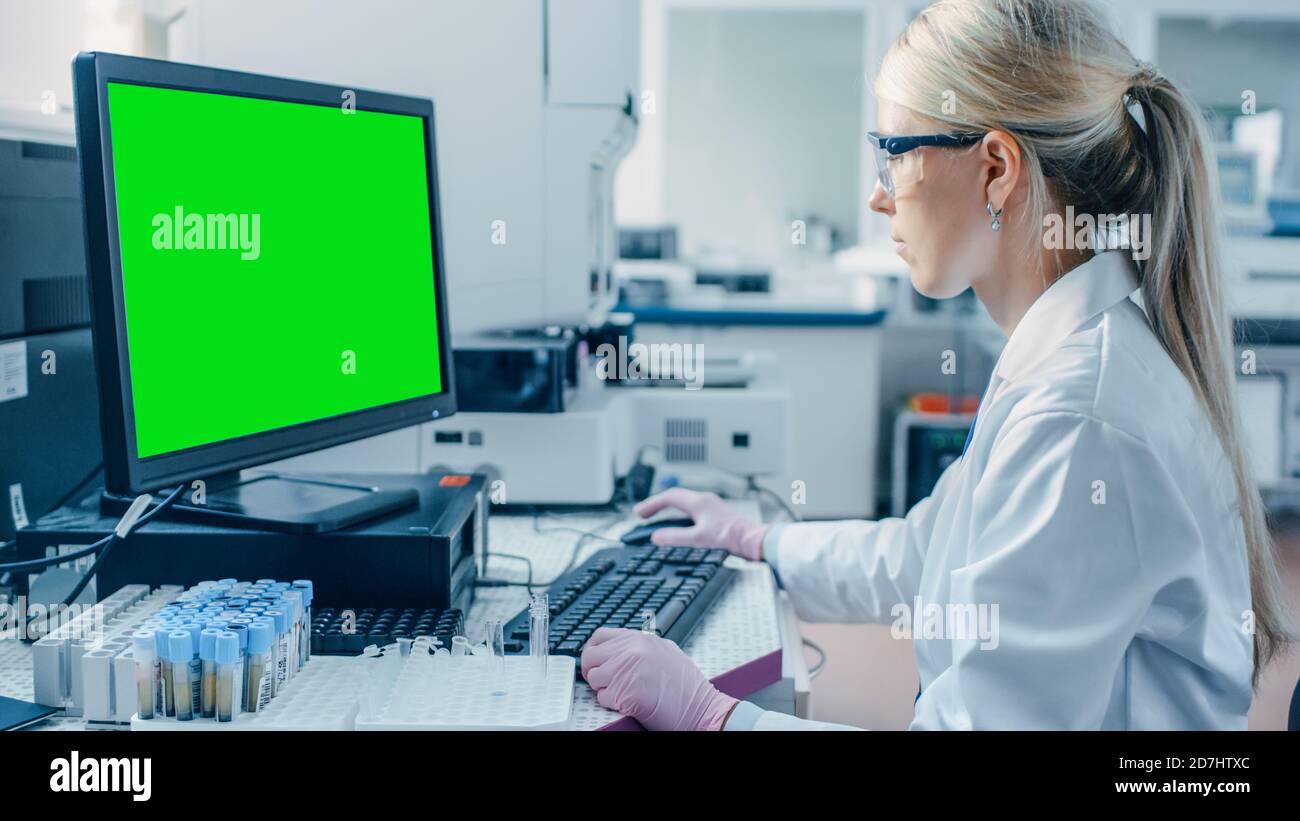 Female Research Scientist Sits at His Workplace in Laboratory, Uses ...